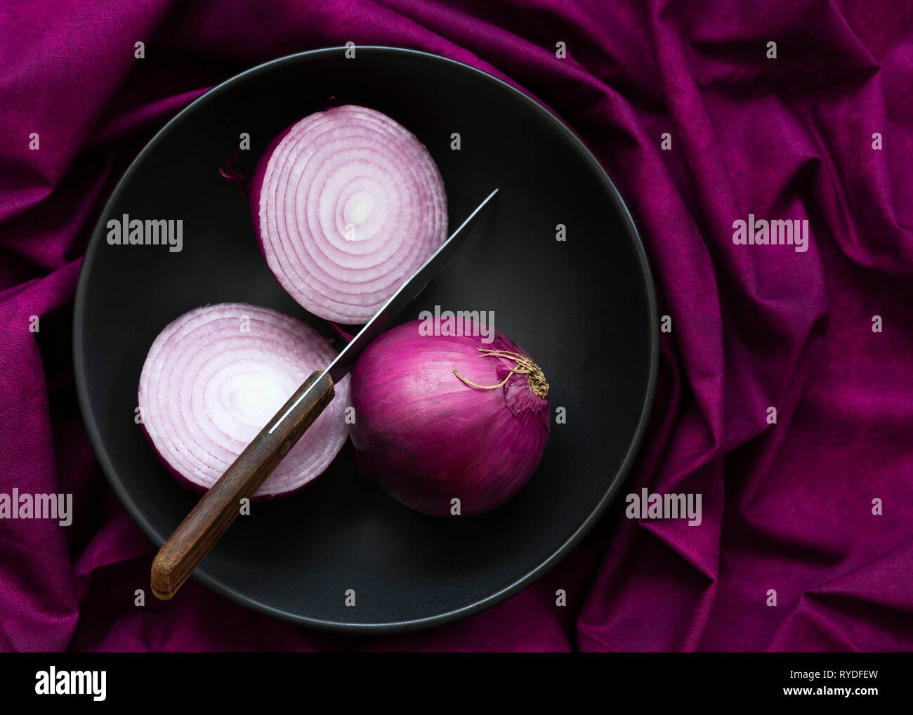 A red onion cut in half with a whole red onion Stock Photo - Alamy
