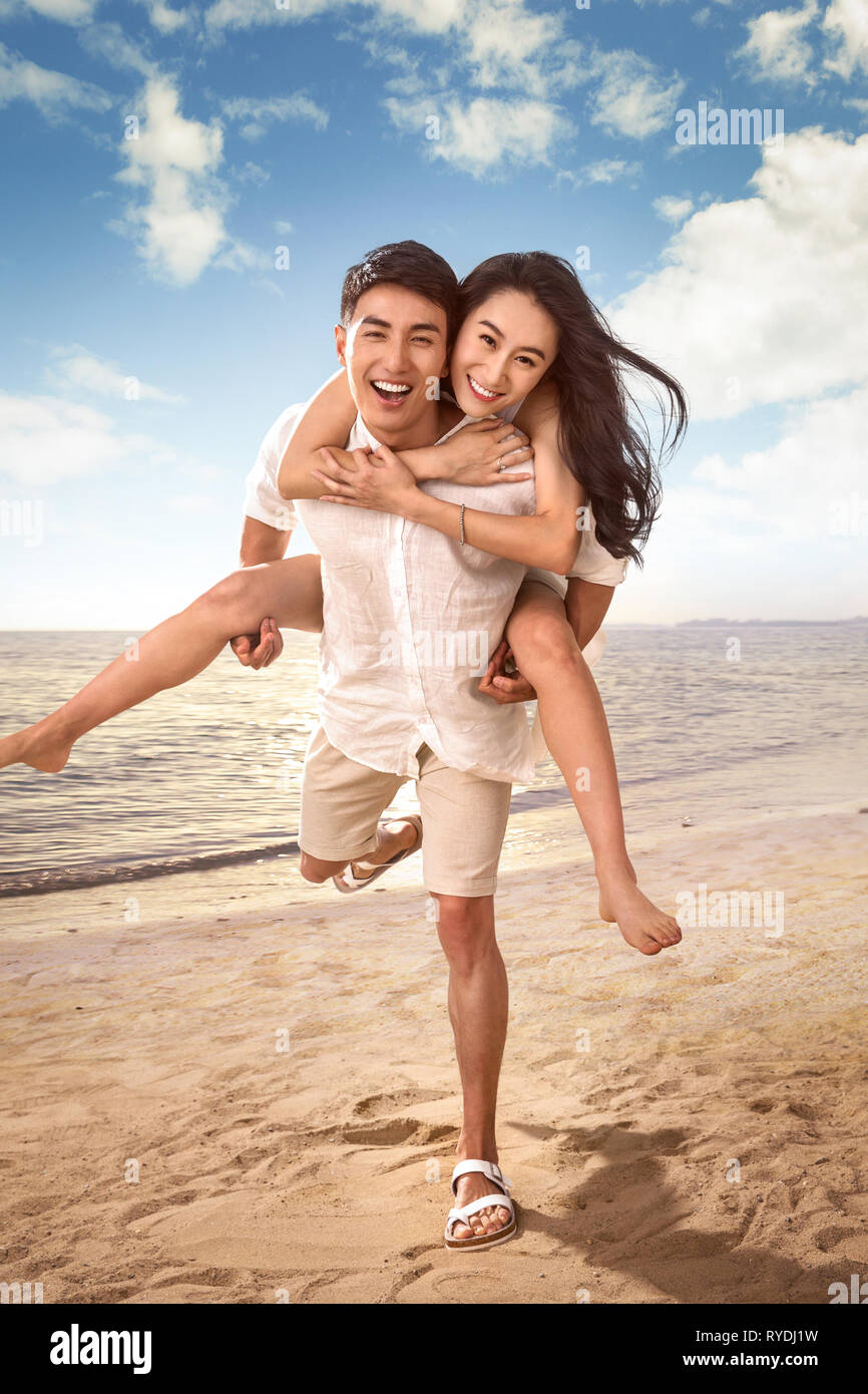 Young lovers play on the beach Stock Photo - Alamy