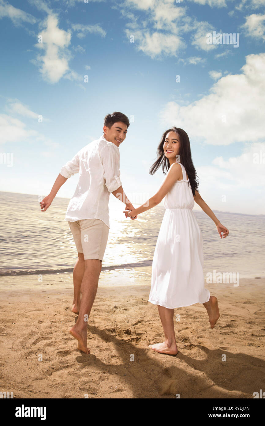 Young lovers play on the beach Stock Photo - Alamy