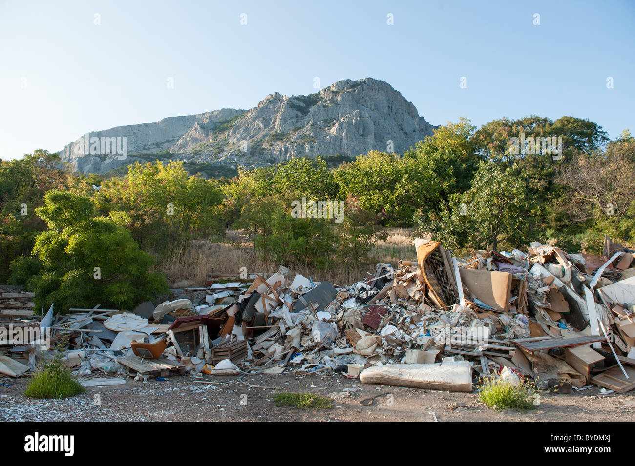 garbage lying outdoors in green park on rock mountain background ...