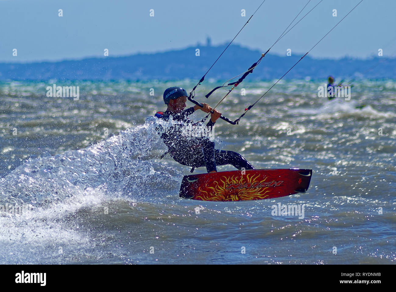 Kite boarder in flying over the waves during a windy day in french ...