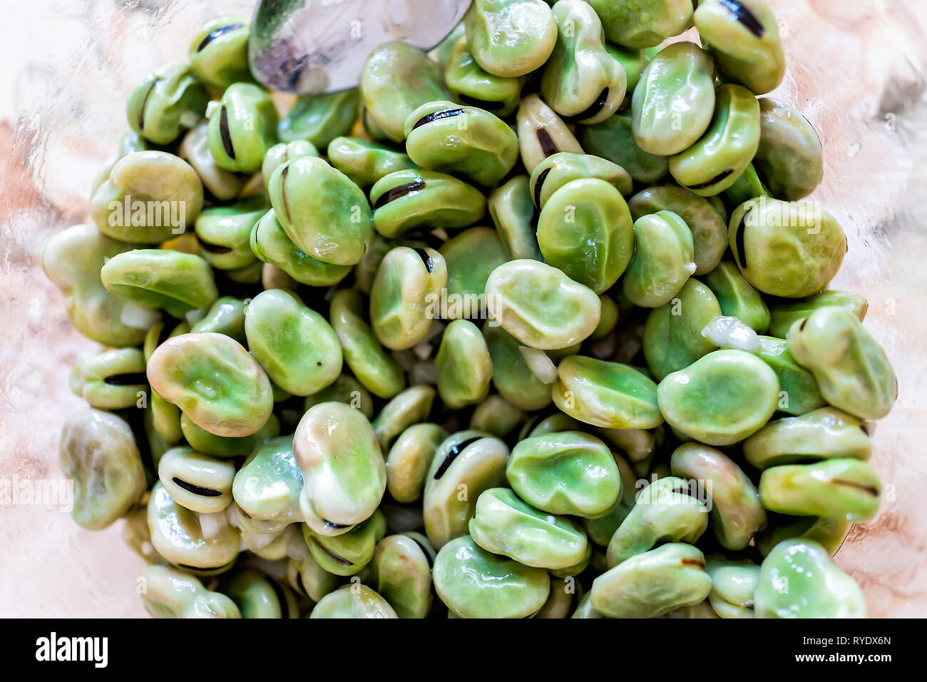 Macro flat top closeup view down of green fava broad beans in glass ...