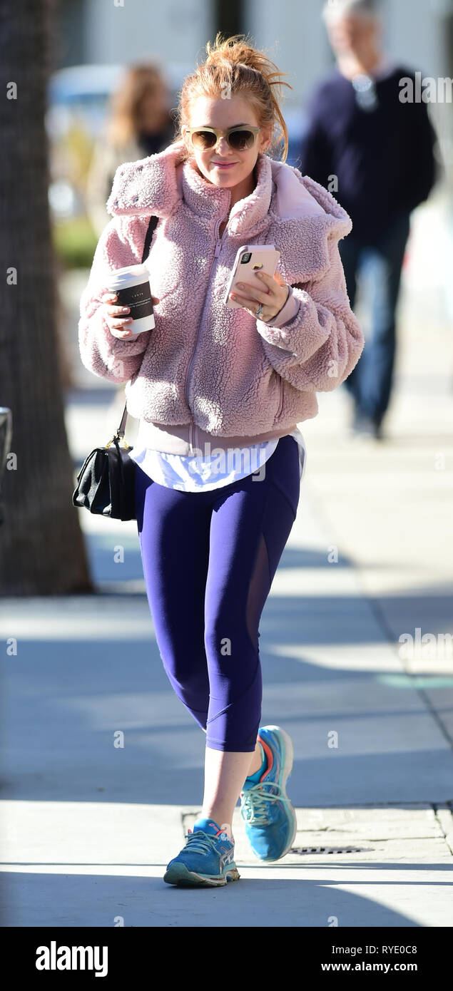 Isla Fisher wears a pink fleece top and purple leggings to go with her ...