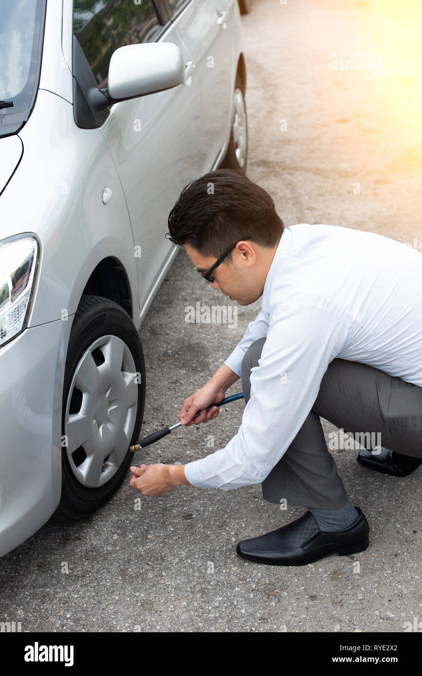 asian man pumping air to his car tyre Stock Photo - Alamy
