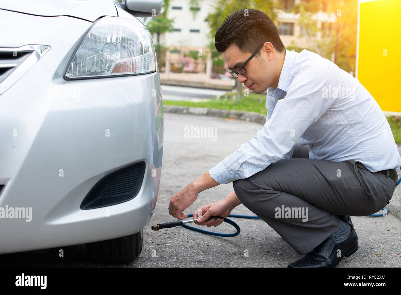 asian man pumping air to his car tyre Stock Photo - Alamy