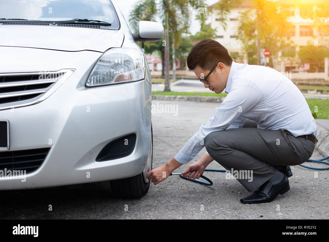 asian man pumping air to his car tyre Stock Photo - Alamy