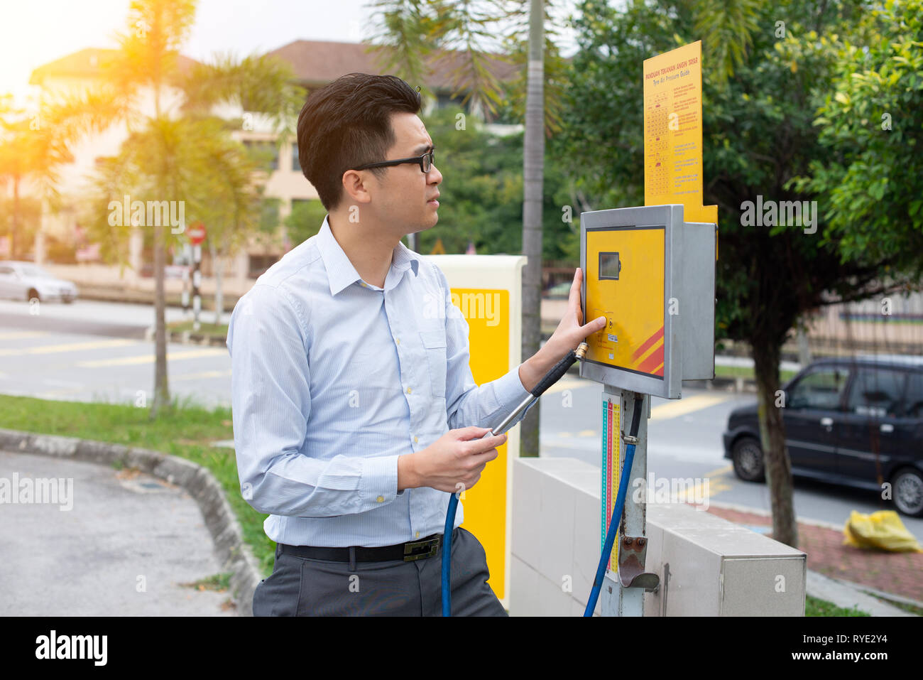 asian man pumping air to his car tyre Stock Photo - Alamy
