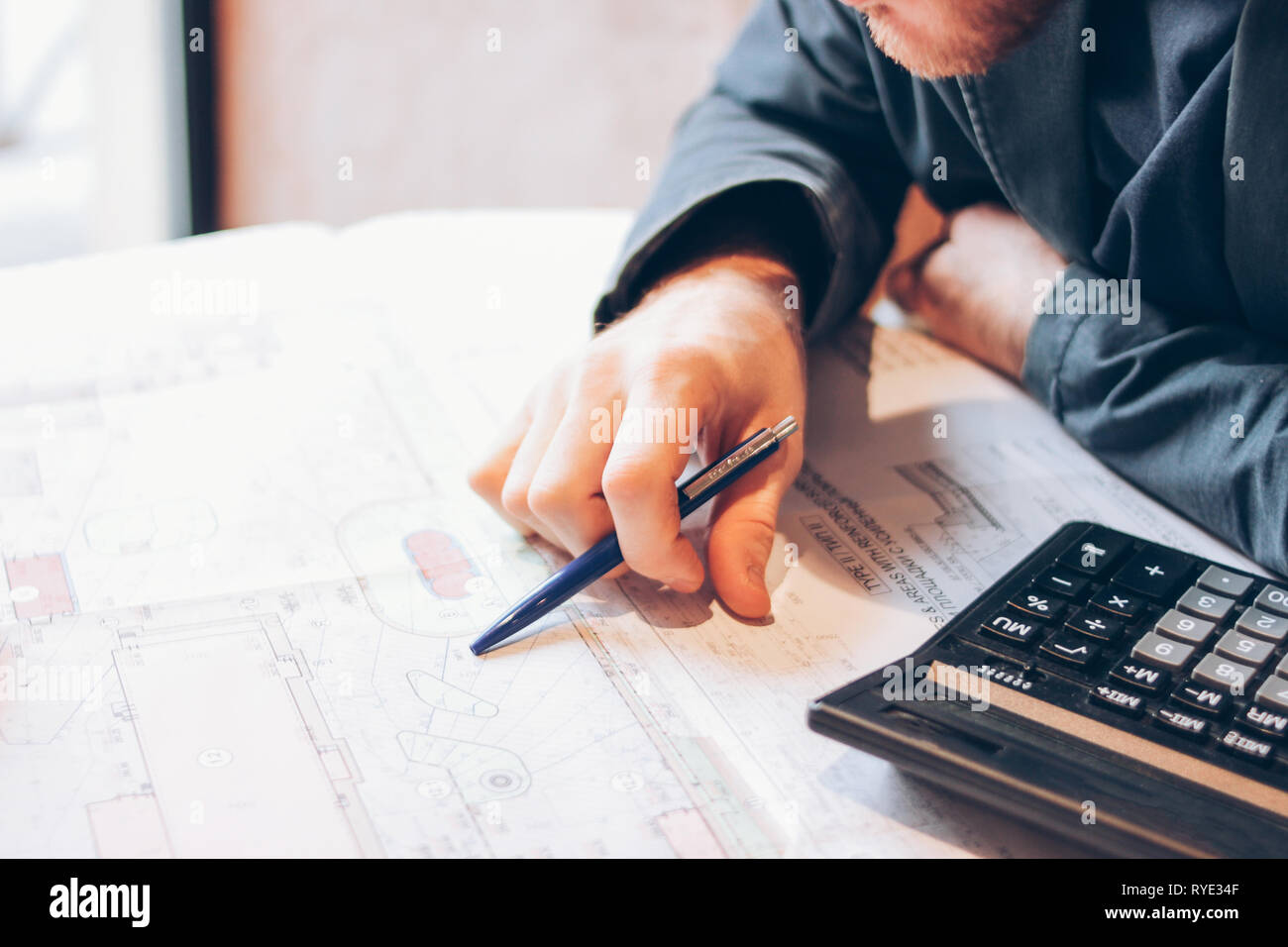 Man engineer designer architect reading drawings at table Stock Photo ...