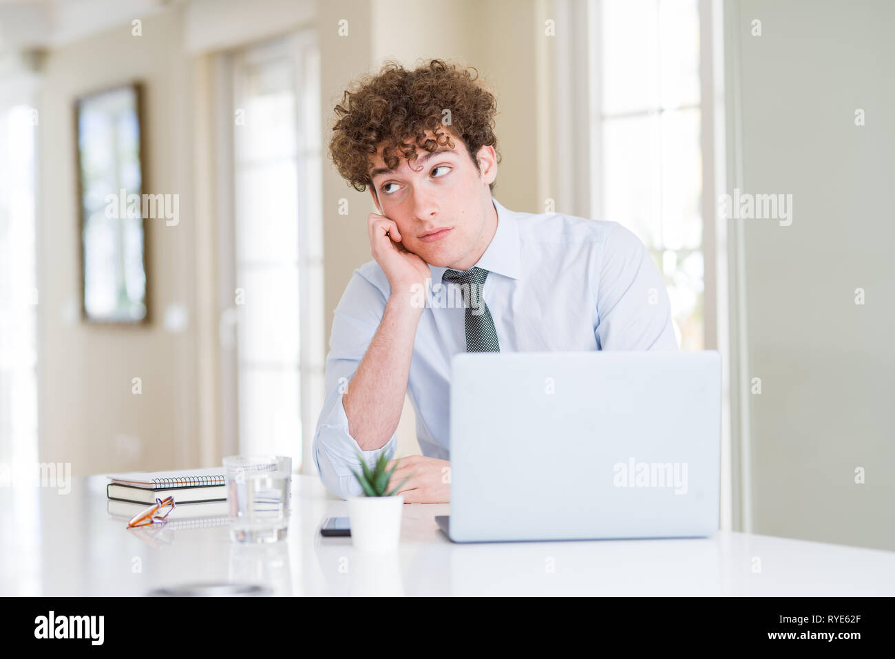 Young business man working with computer laptop at the office thinking ...