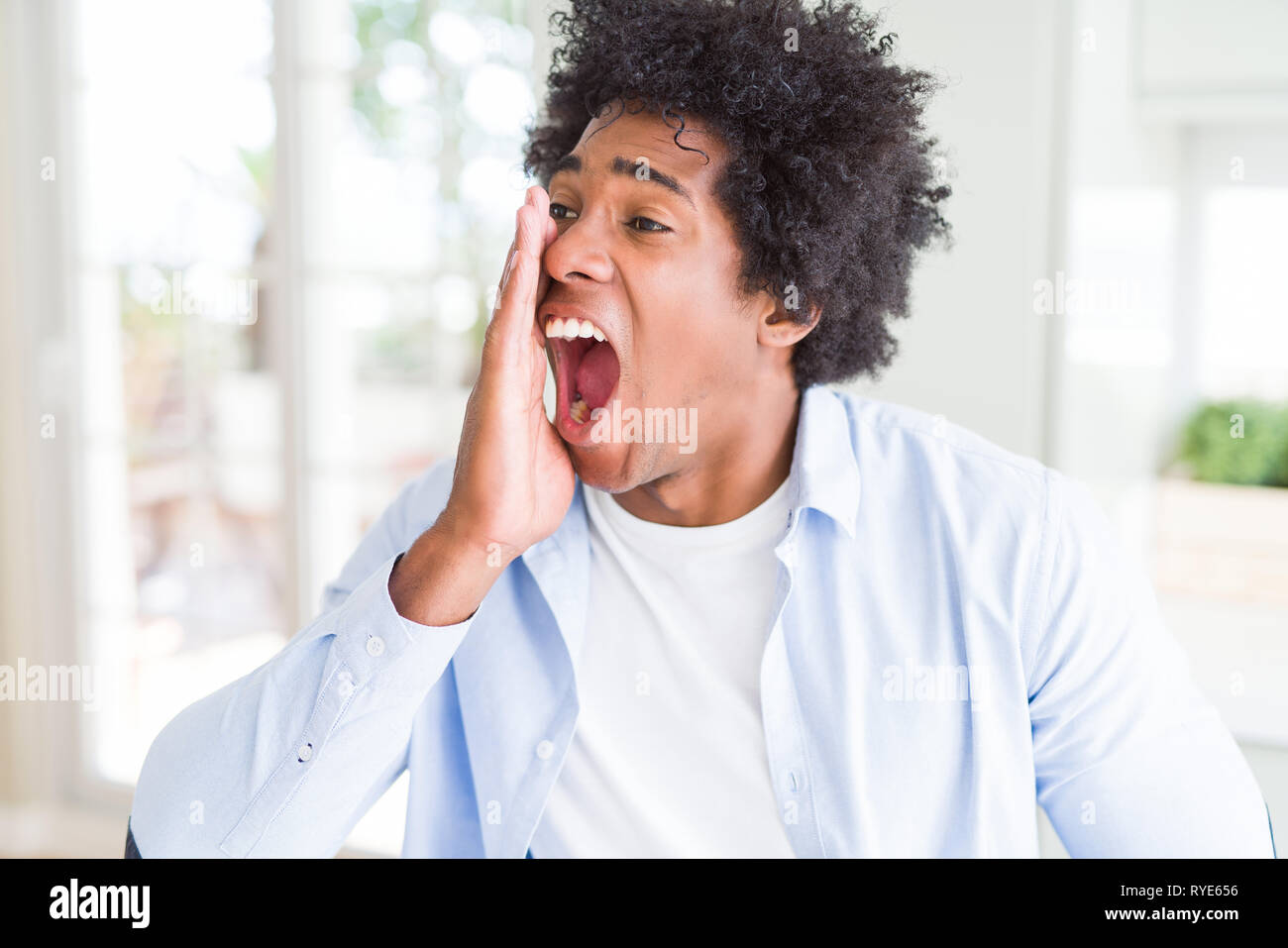 African American man at home shouting and screaming loud to side with ...