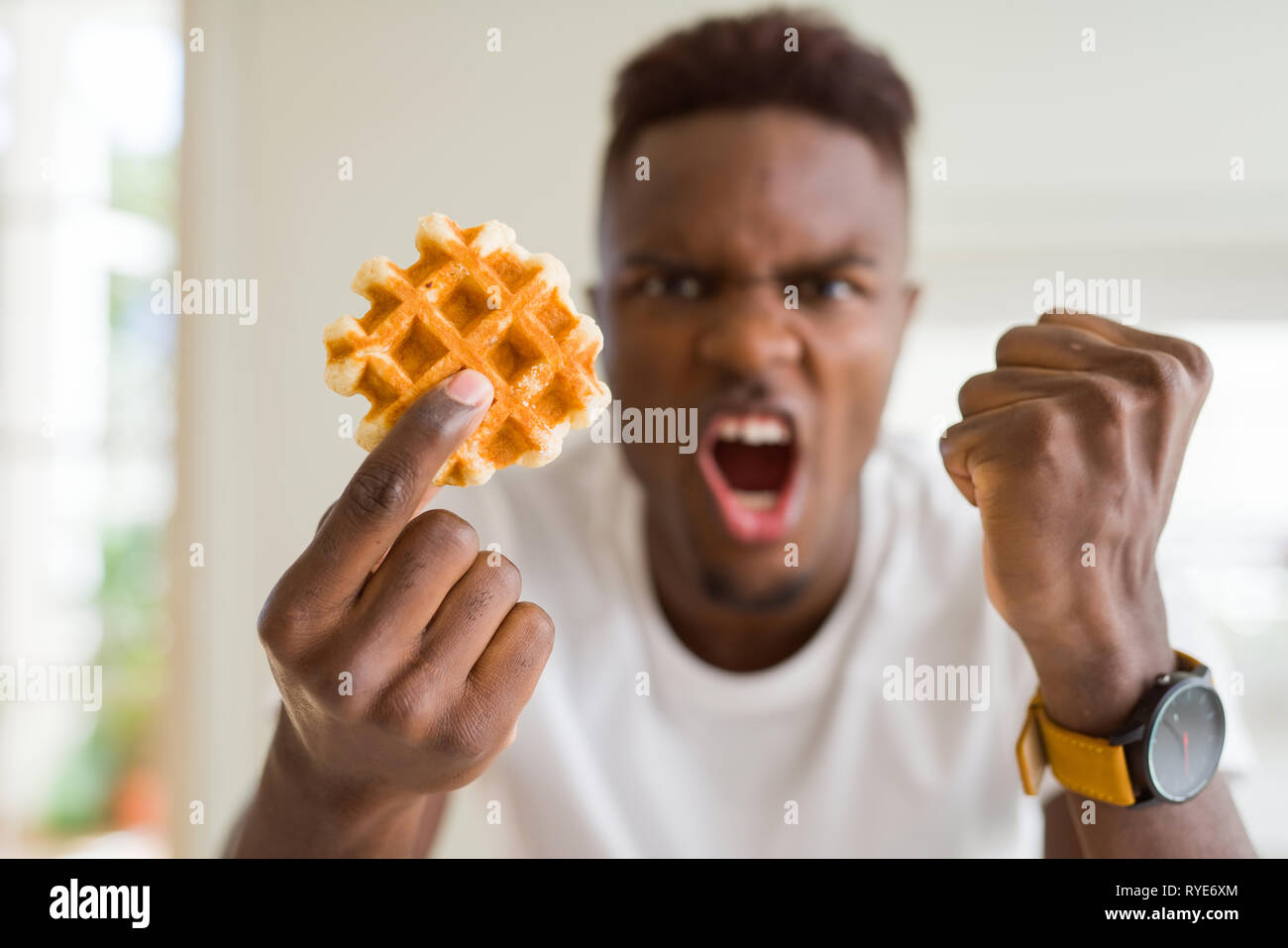 African american man eating sweet Belgian waffle annoyed and frustrated ...