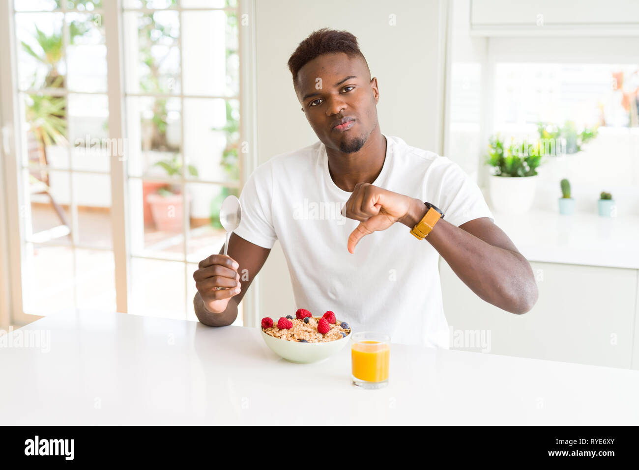 Young african american man eating healthy breakfast in the morning with ...