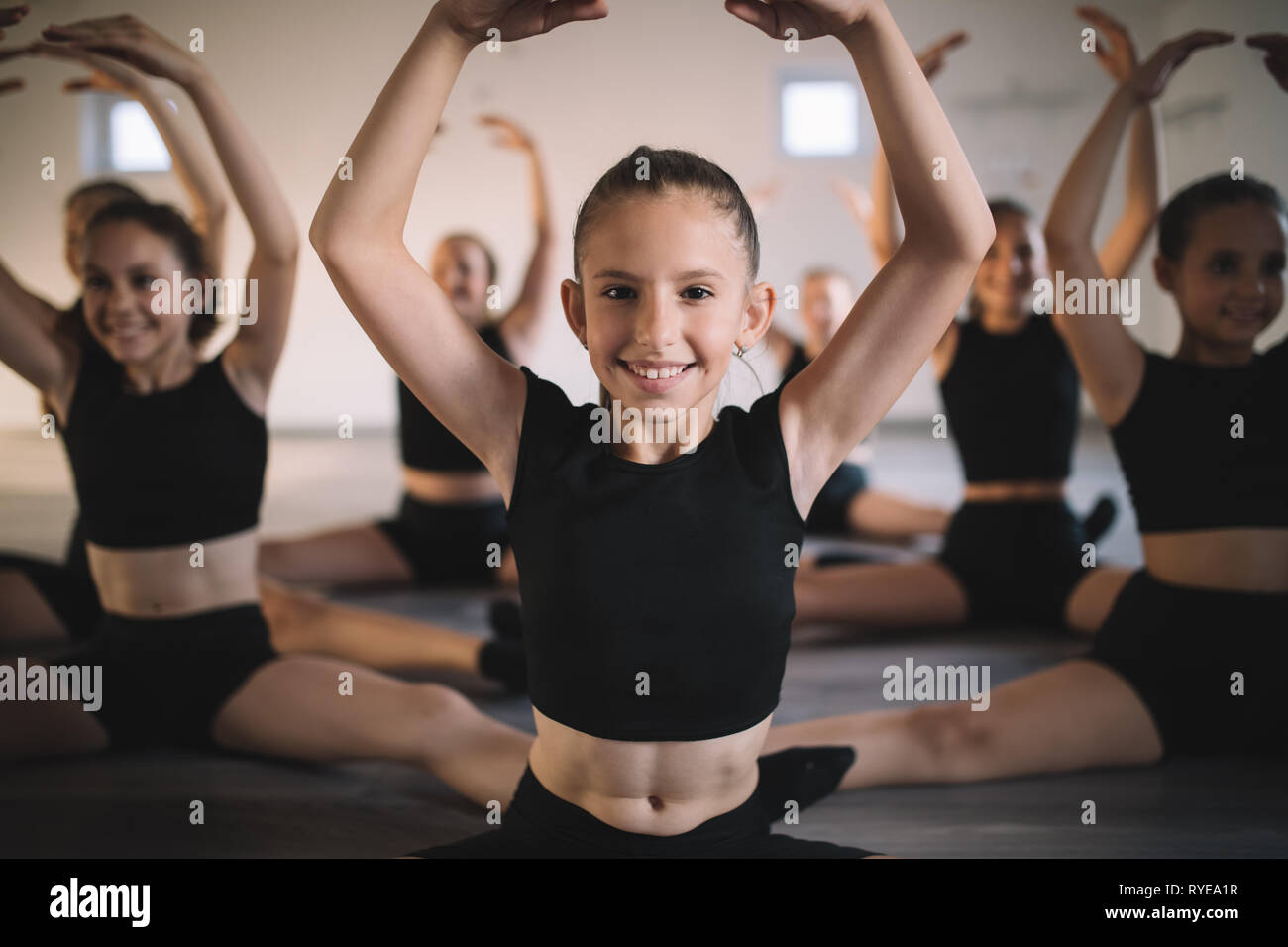 Group of fit happy children exercising ballet in studio together Stock ...
