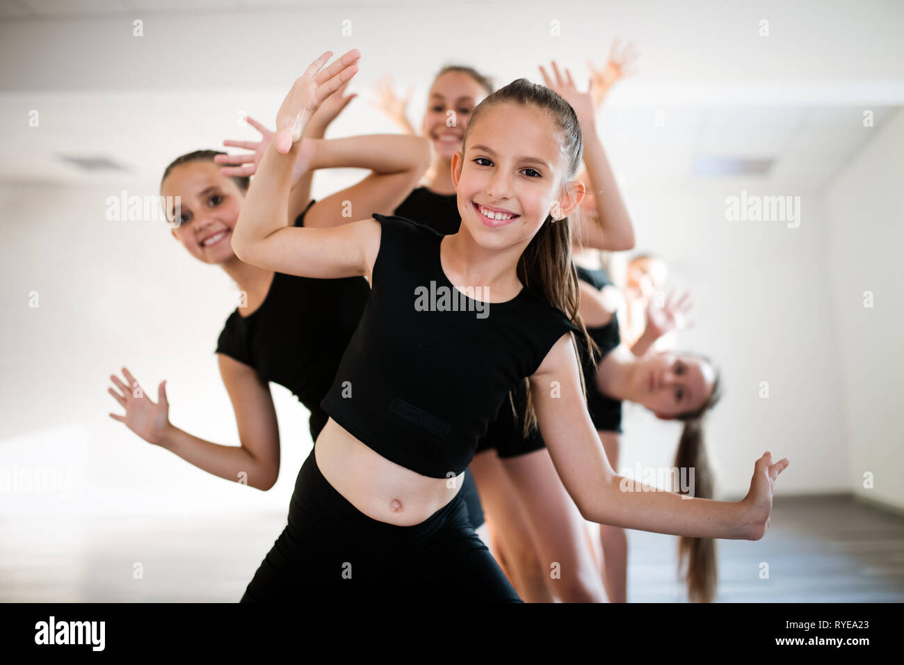 Group of fit happy children exercising dancing and ballet in studio ...