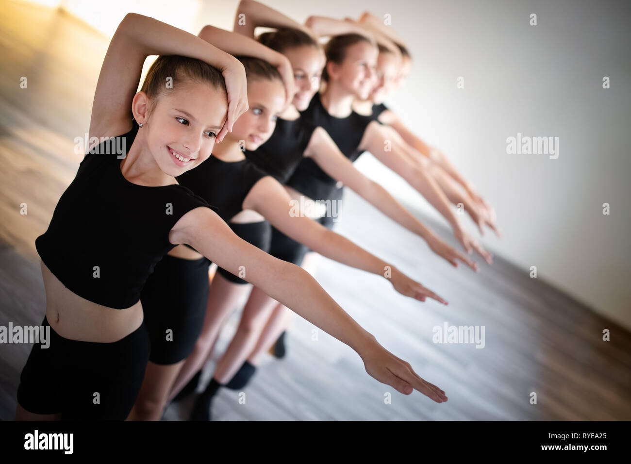 Group of fit happy children exercising ballet in studio together Stock ...