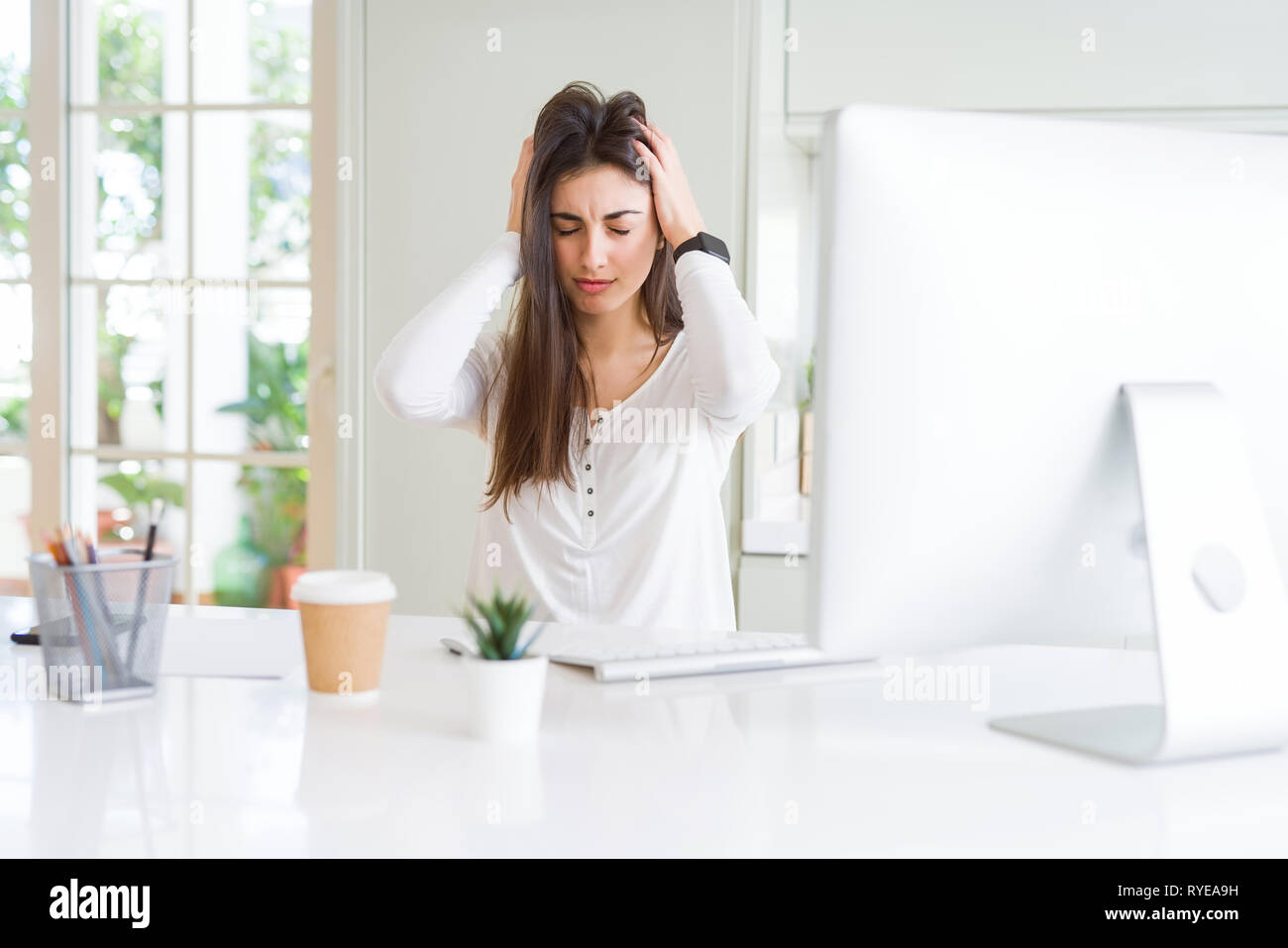 Beautiful young woman working using computer suffering from headache ...