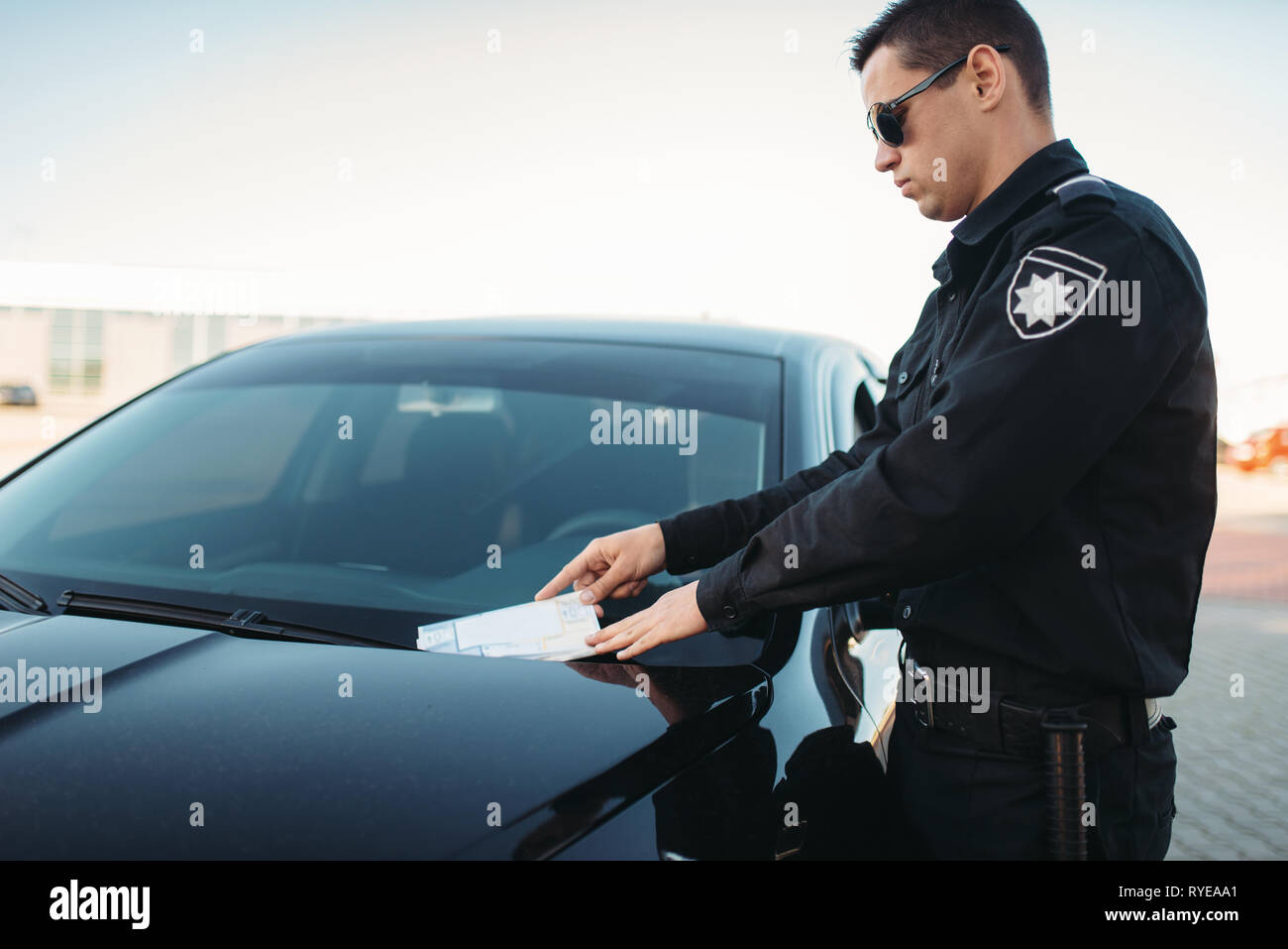 Male policeman in uniform writes a fine on road Stock Photo - Alamy