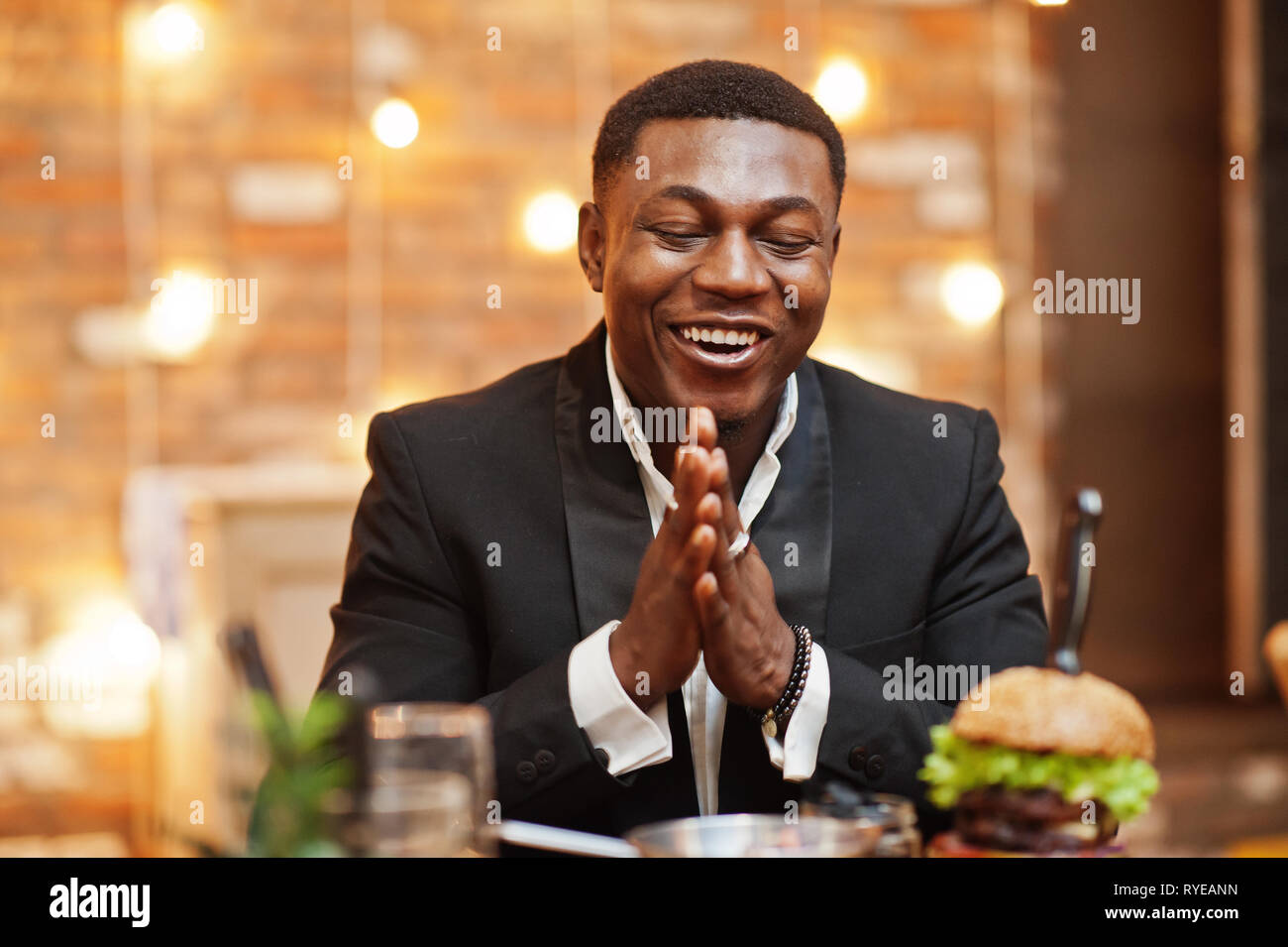 Hungry and happy rubs hands. Respectable young african american man in ...