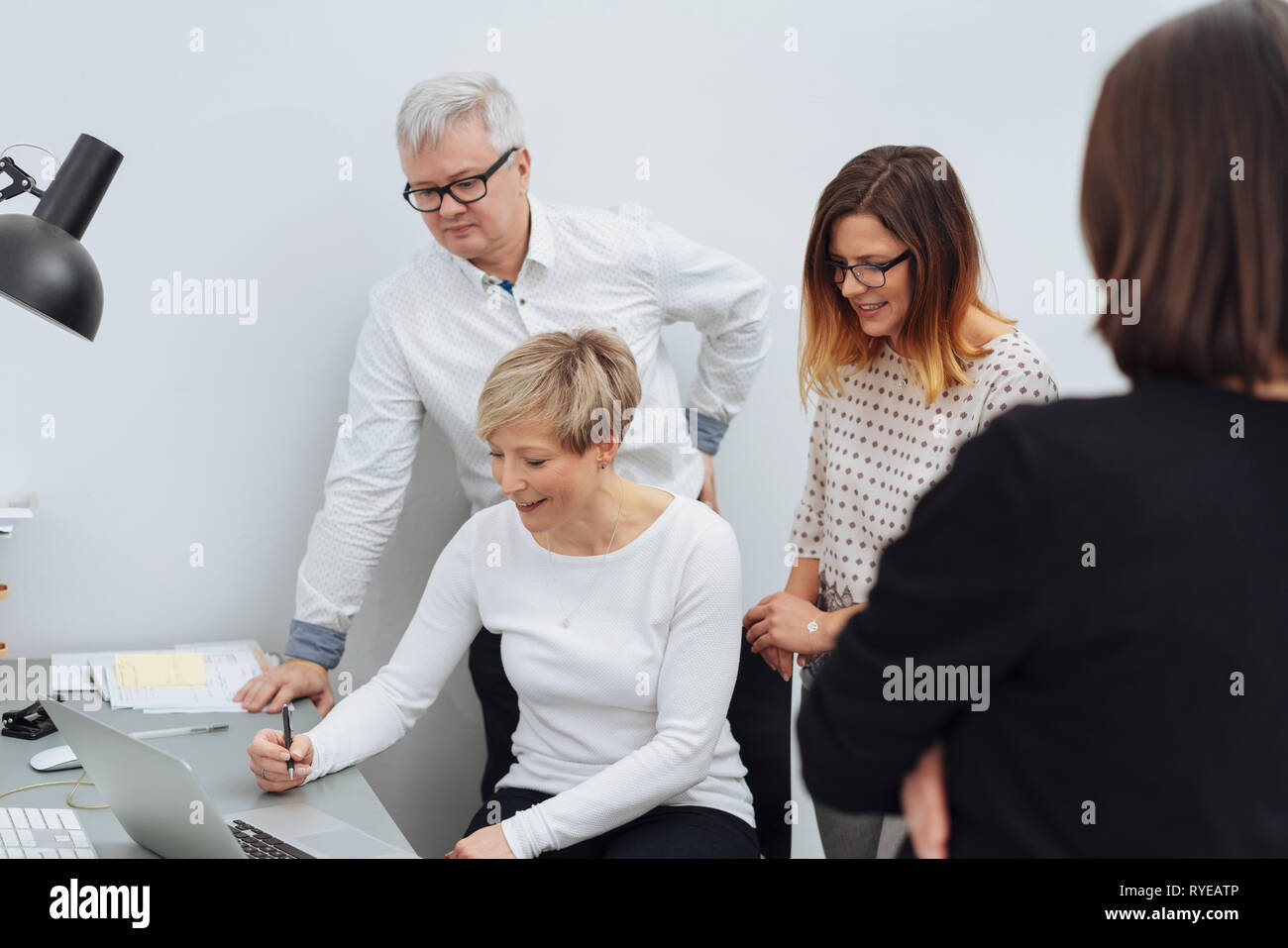 Business people grouped around laptop hi-res stock photography and ...