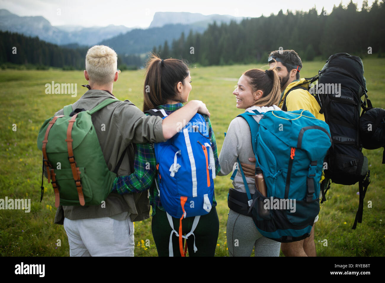 Group of hikers walking on a mountain and smiling Stock Photo - Alamy