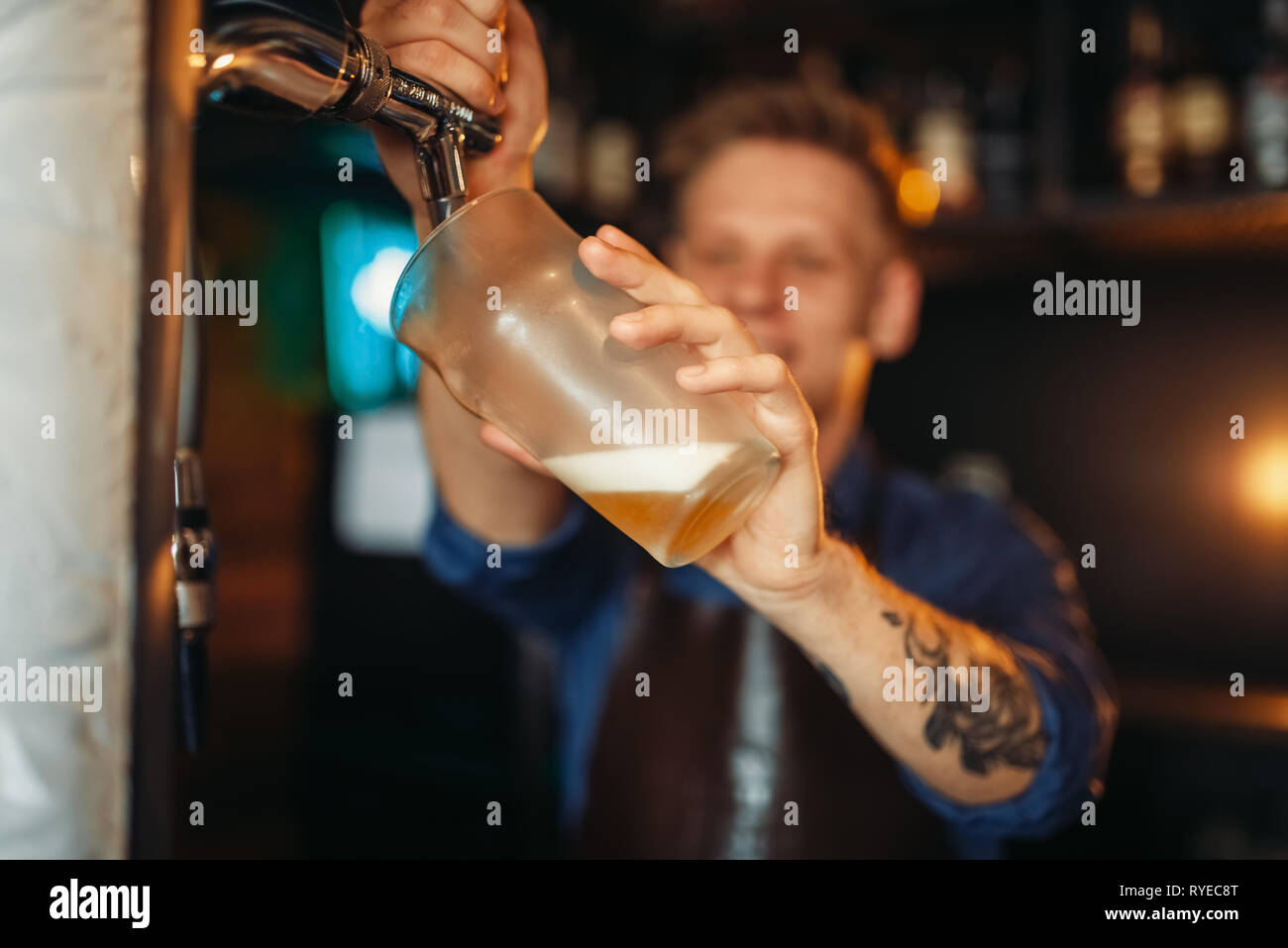 Male barman pouring beer at the bar counter Stock Photo - Alamy