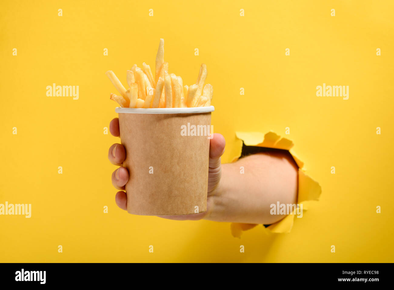 Hand giving French fries Stock Photo - Alamy