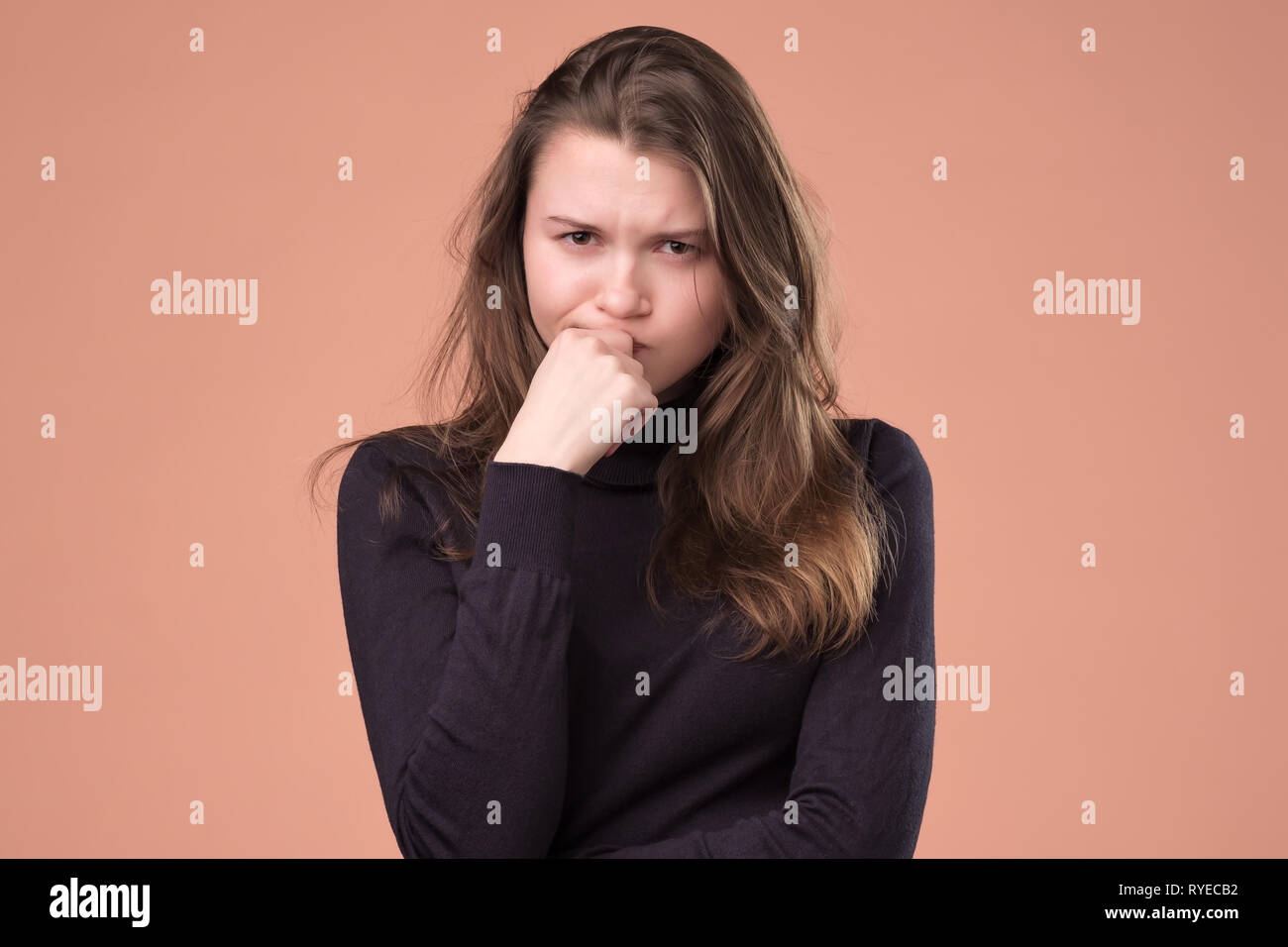 sad woman holding hands on face on brown background Stock Photo - Alamy