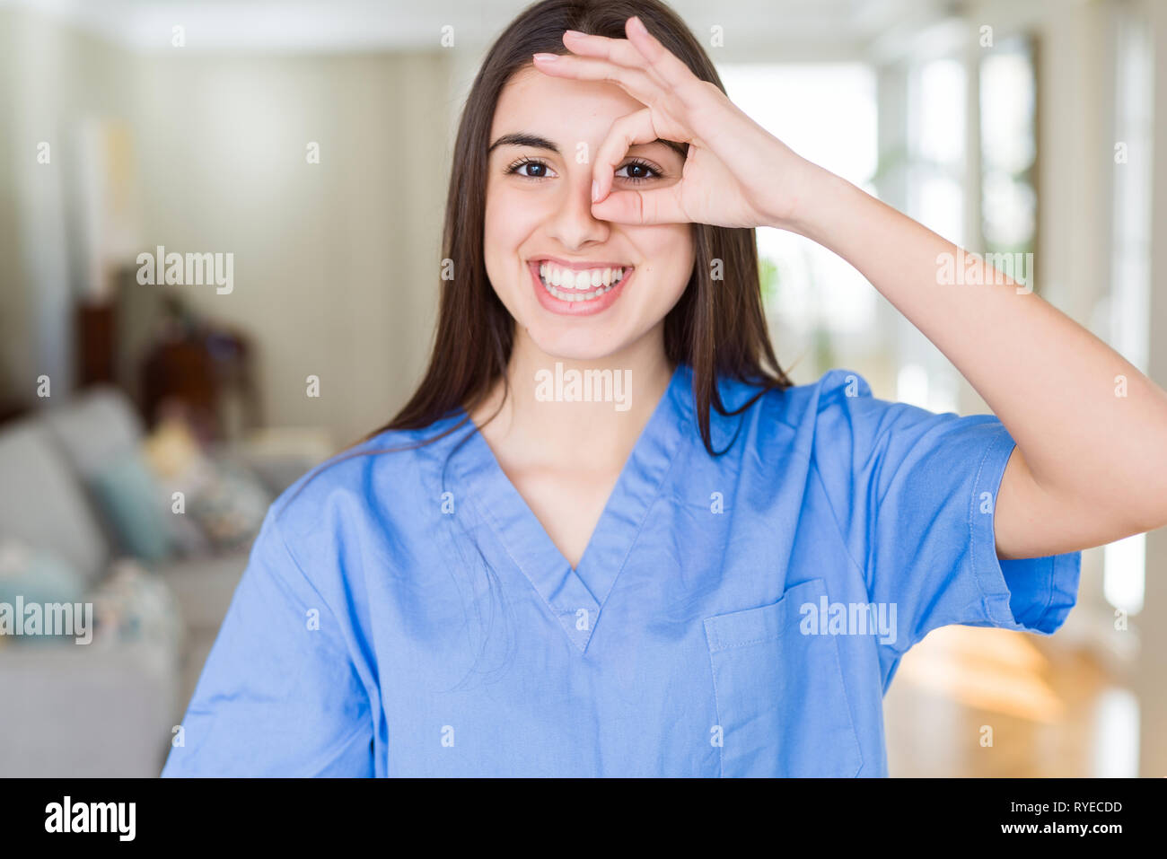 Beautiful young nurse woman at the clinic doing ok gesture with hand ...