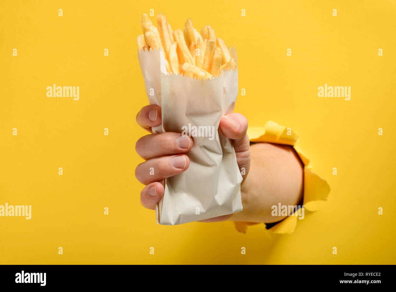 Hand holding French fries Stock Photo - Alamy