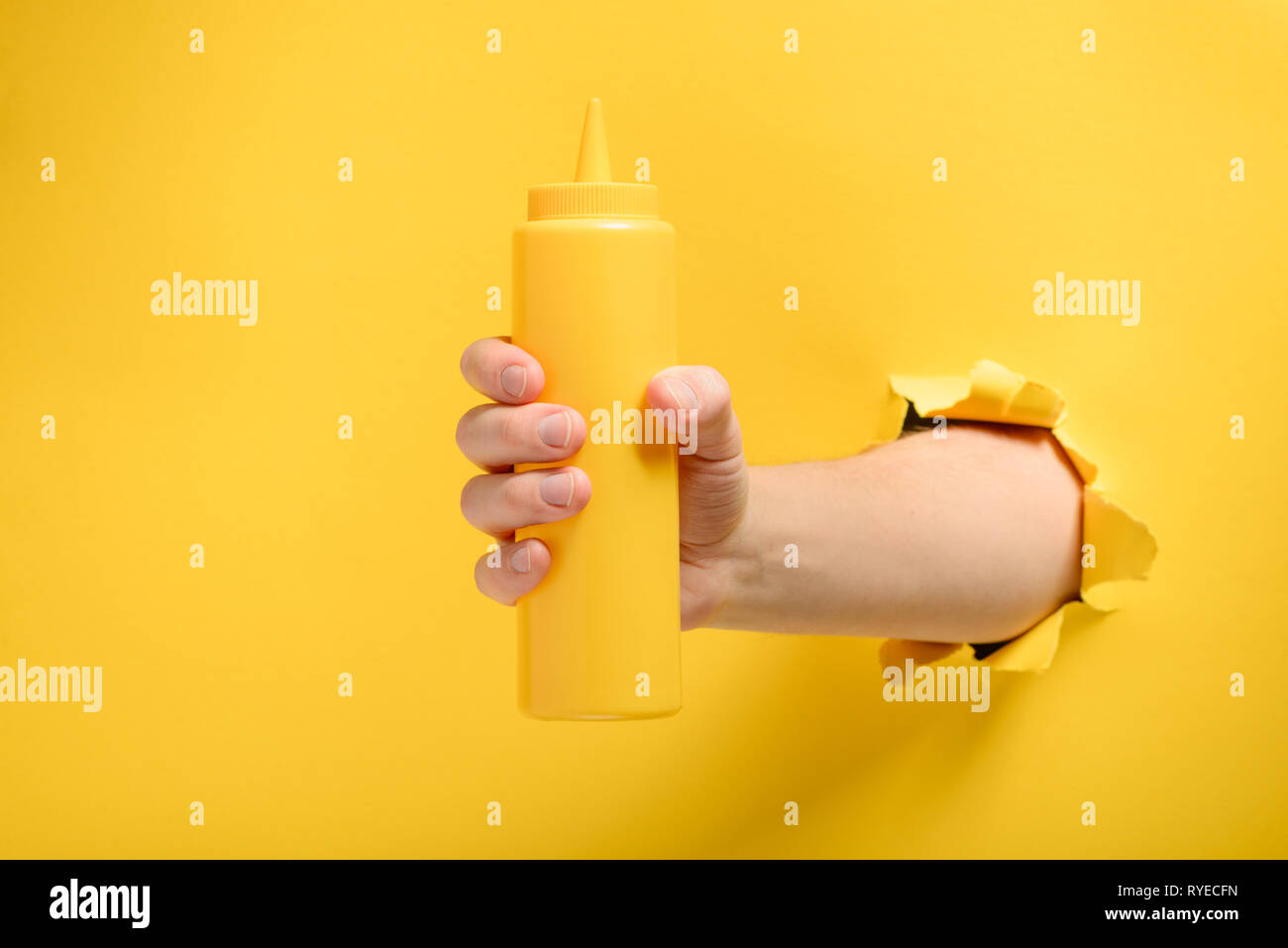 Hand holding a mustard bottle Stock Photo - Alamy