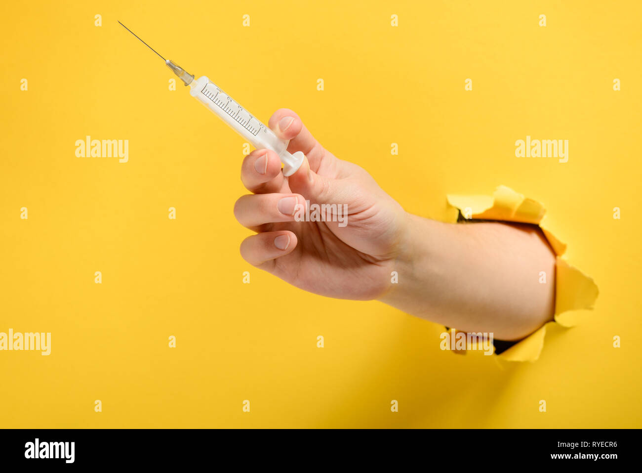 Hand holding a syringe Stock Photo - Alamy