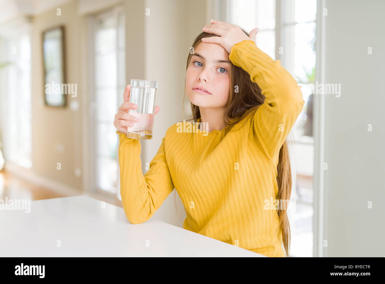 Beautiful young girl kid drinking a fresh glass of water stressed with ...