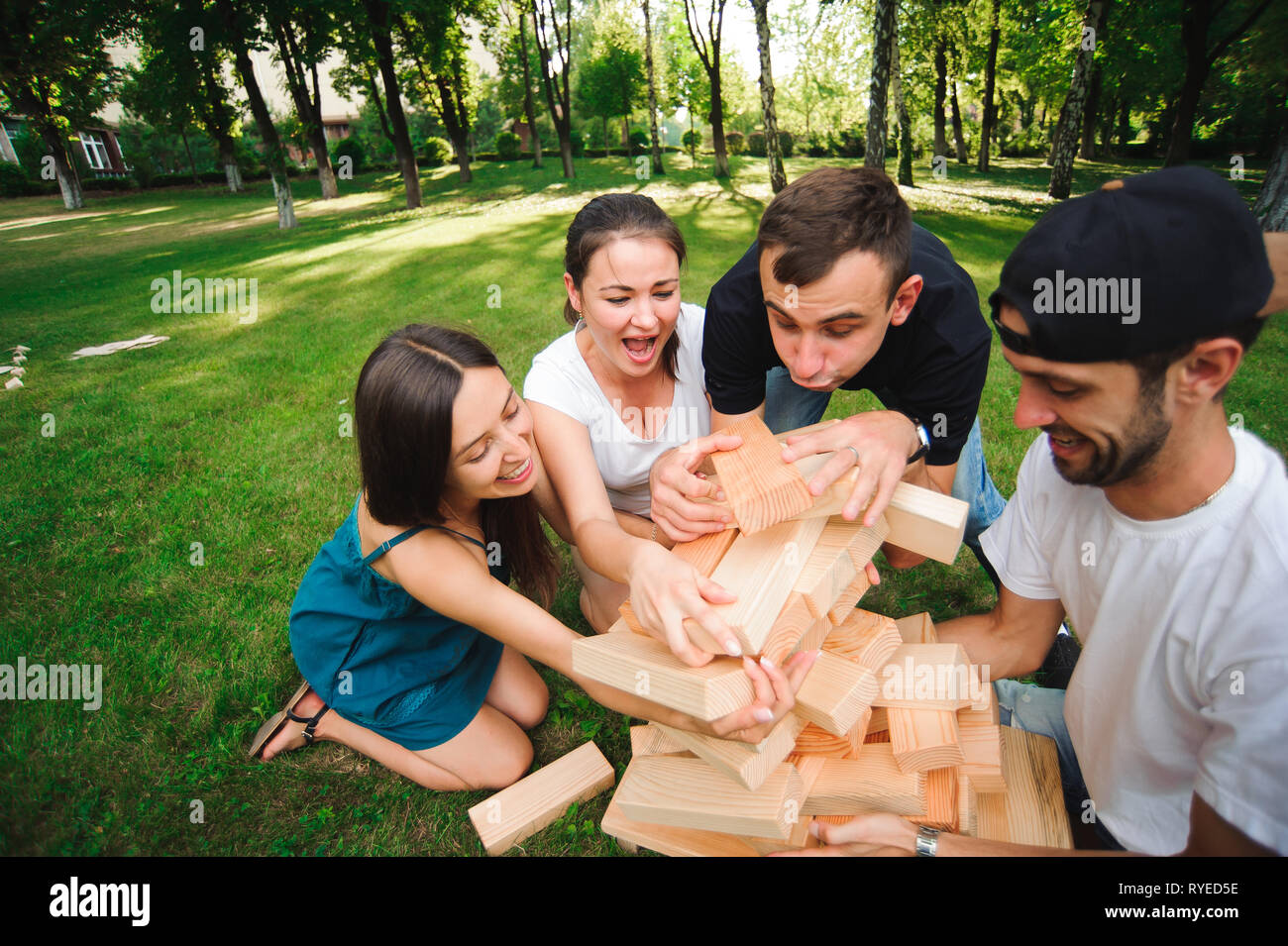 Friends playing board game outdoors. Group game of physical skill with ...