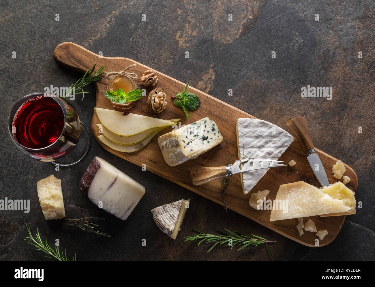 Cheese platter with organic cheeses, fruits, nuts and wine on stone ...