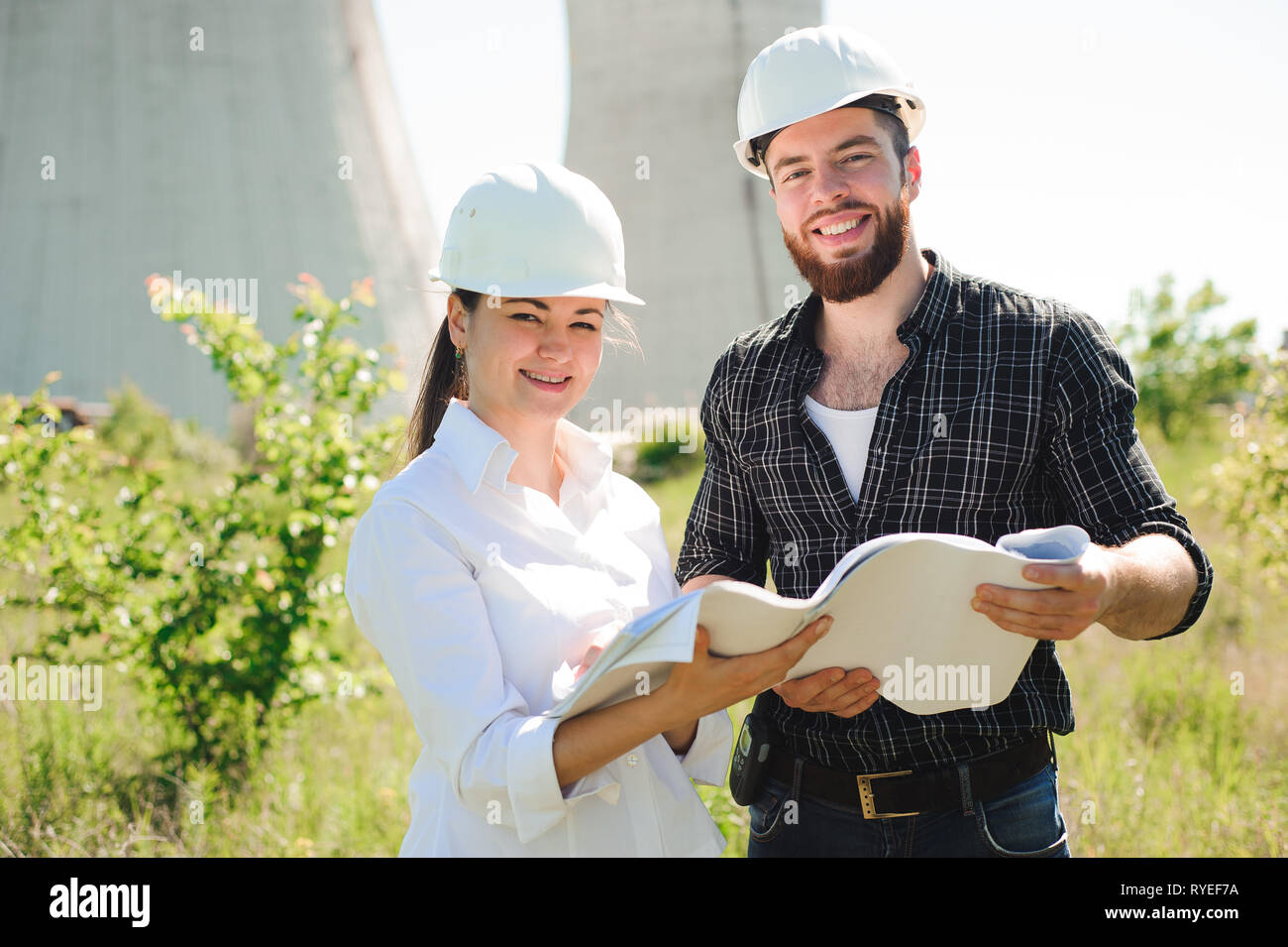 two engineers standing at electricity station, discussing plan Stock ...
