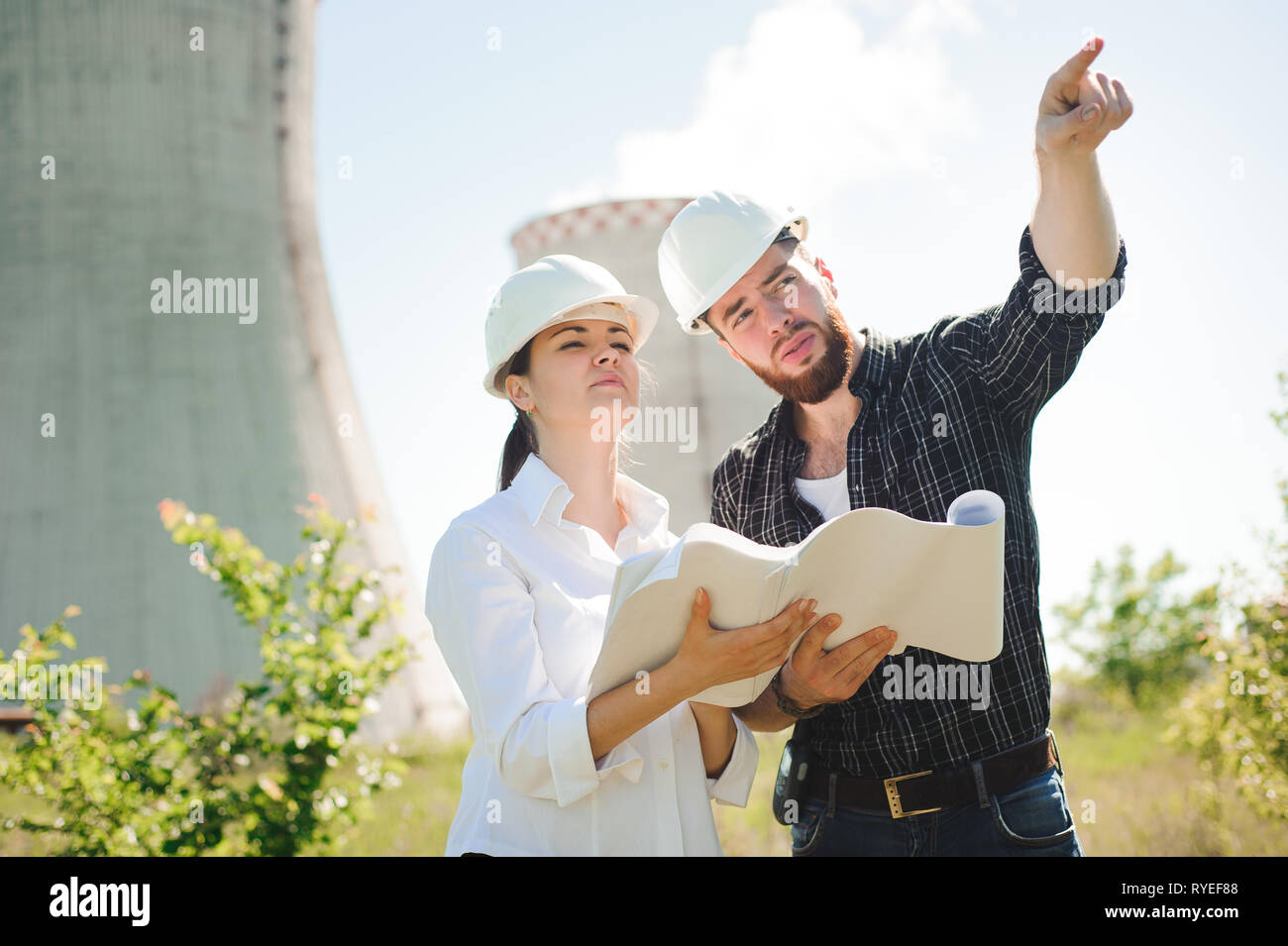two engineers standing at electricity station, discussing plan Stock ...
