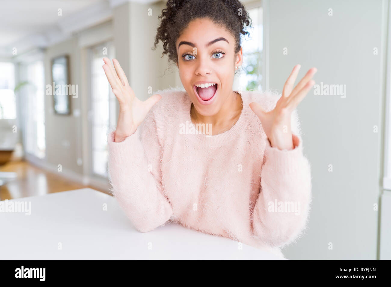 Beautiful young african american woman with afro hair celebrating crazy ...