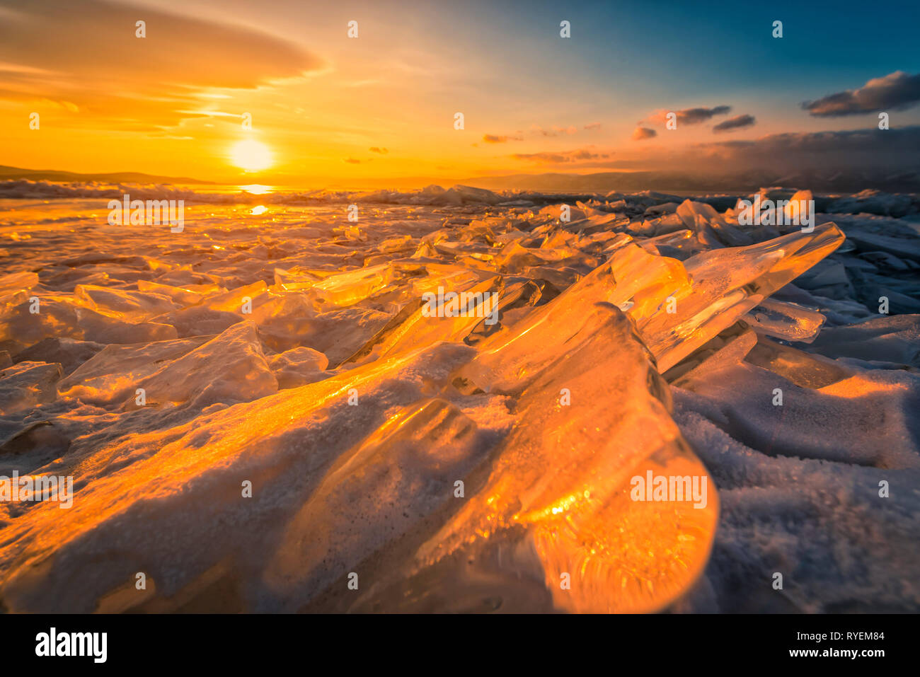 Sunset sky with natural breaking ice over frozen water on Lake Baikal ...