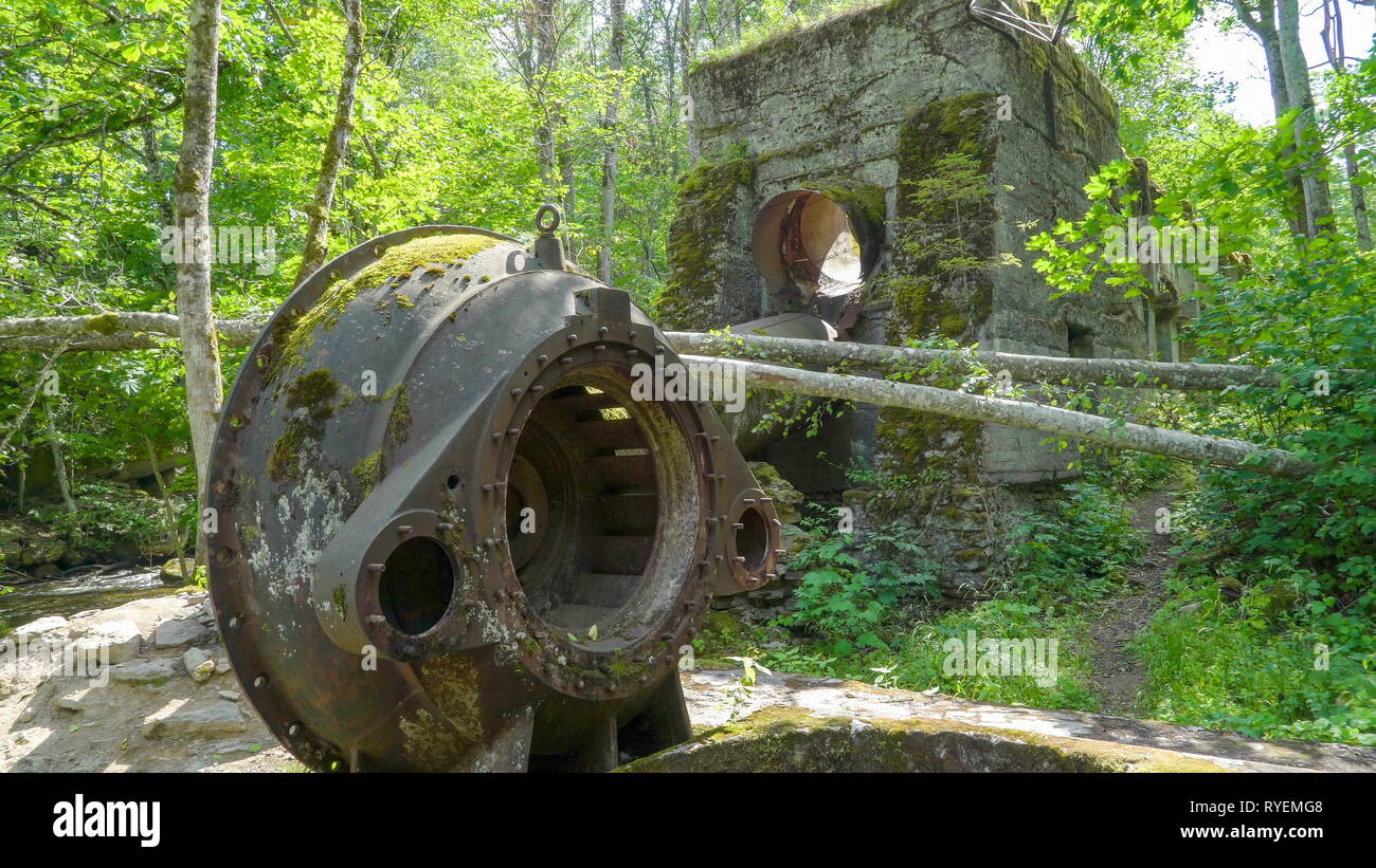 An old building of the hydroelectric power station with lots of forest ...