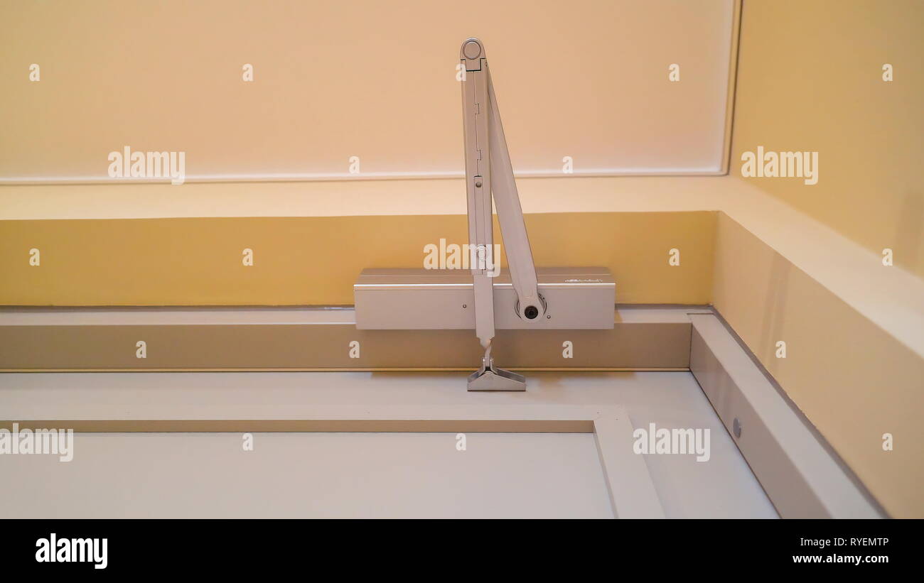 The metal spring of the door of the house mounted on the wall of the ...