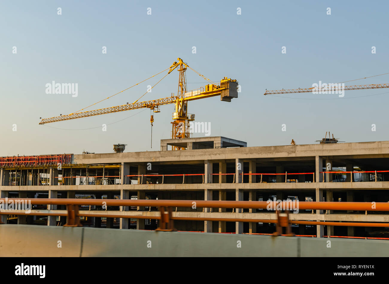Crane above building under construction against the sky Stock Photo - Alamy