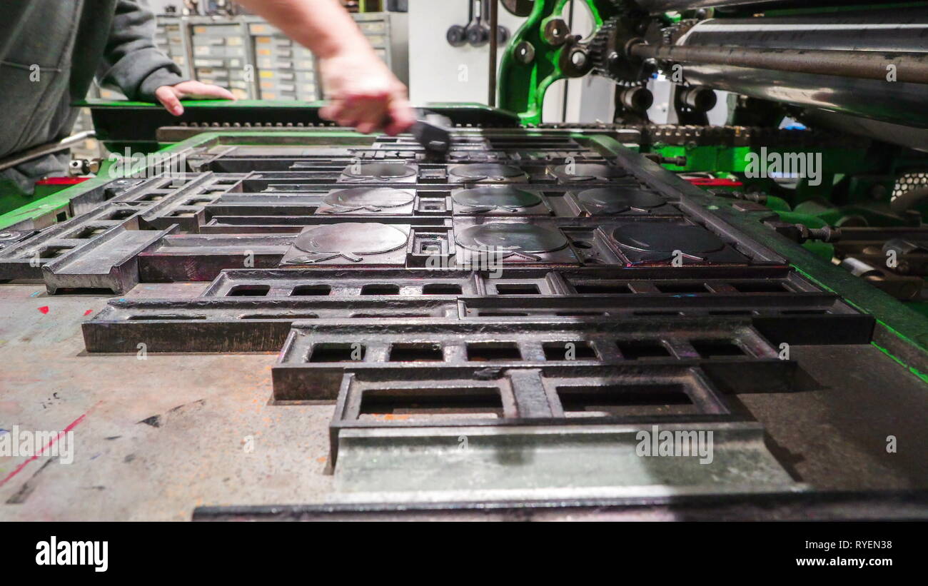 Scrubbing of black ink on the apple metal forms inside the old printing ...