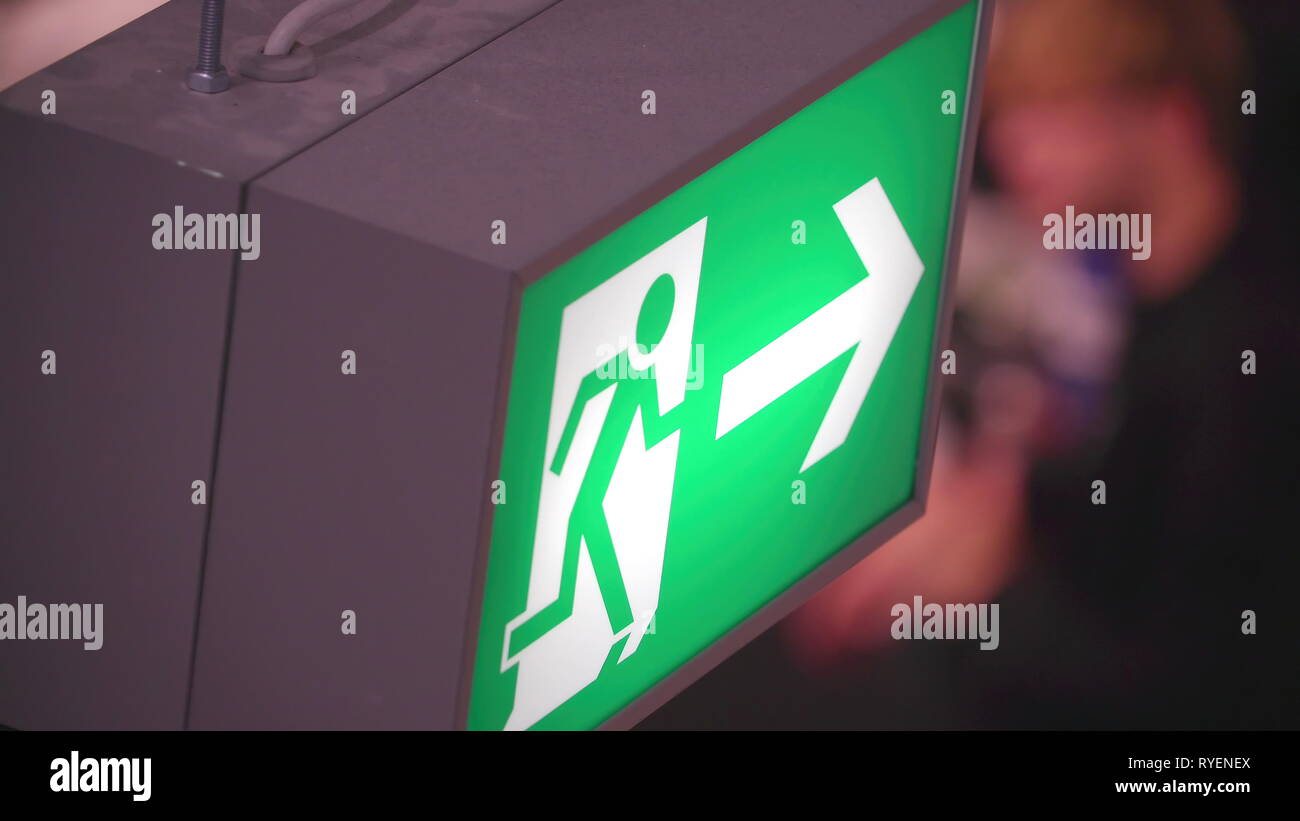 An exit green signage on the ceiling of the building as an emergency ...