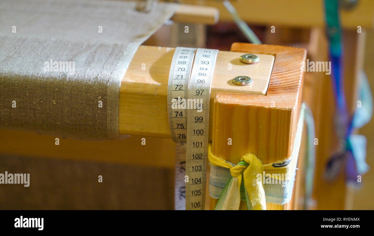 The yellow tape measure rolled around the wood of the traditional ...