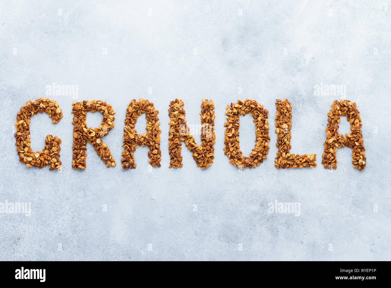 Word granola written with roasted oats and nuts granola. Gray ...