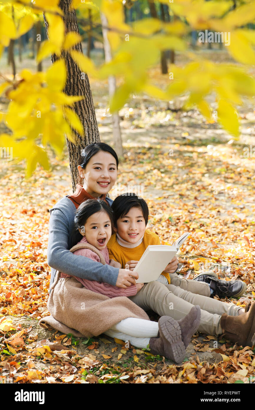 Mother and child in reading under the tree Stock Photo - Alamy