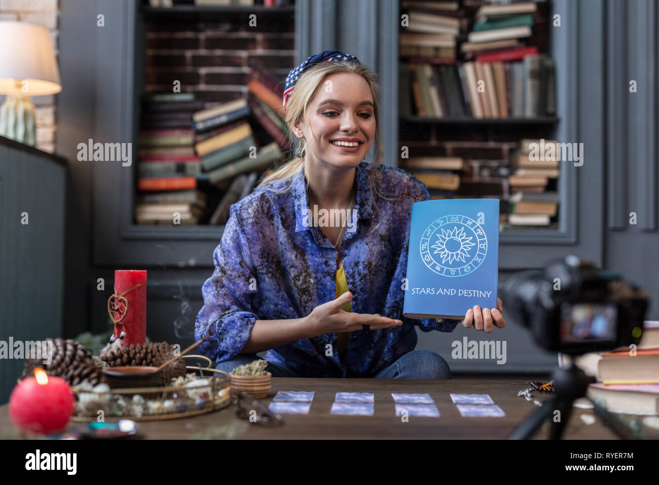 Nice cheerful woman pointing at the book Stock Photo - Alamy