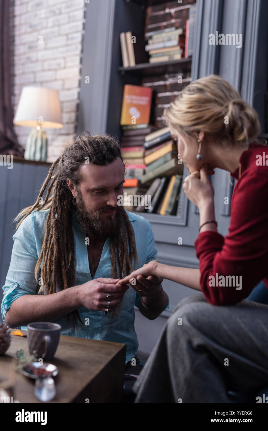 Nice joyful man reading the palm of his client Stock Photo - Alamy