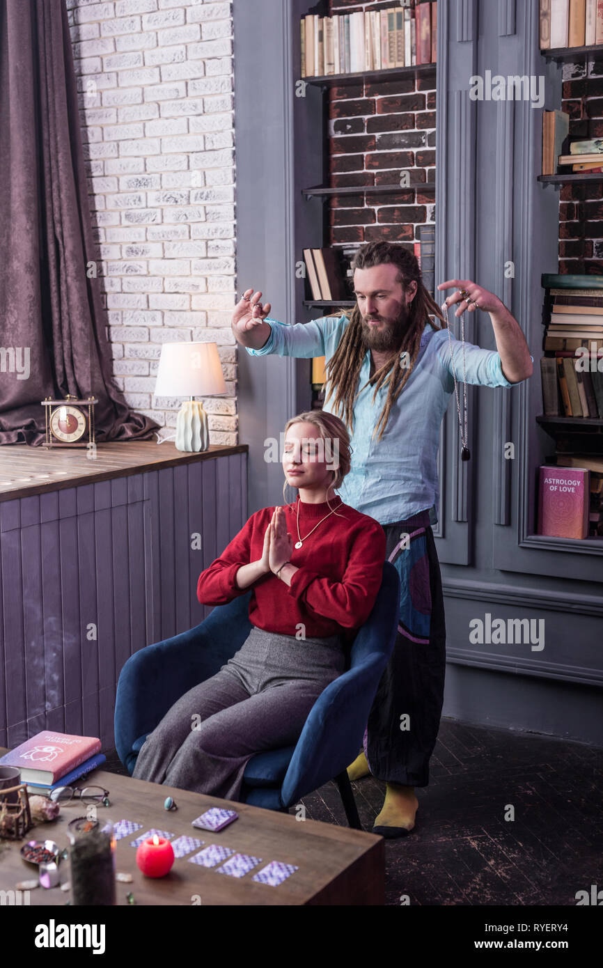 Nice long haired man performing a magic ritual Stock Photo - Alamy