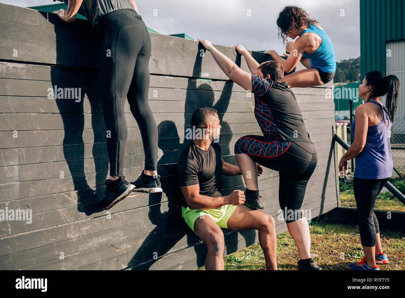 Participants in obstacle course climbing wall Stock Photo - Alamy